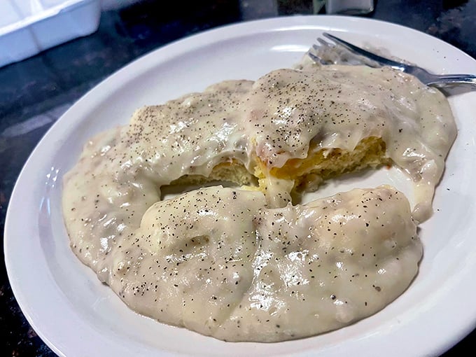 Behold, the star of our show! This biscuit, drowning in perfectly peppered sausage gravy, isn't just breakfast—it's an edible hug.