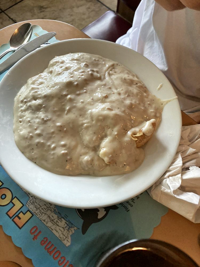 Biscuits and gravy that would make your Southern grandmother weep with joy—a creamy, peppery blanket covering what lies beneath.