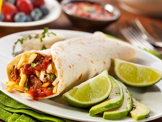 This isn't just a burrito—it's edible architecture. Perfectly wrapped with fresh lime wedges standing by, ready to add that crucial citrus zing to every magnificent bite.