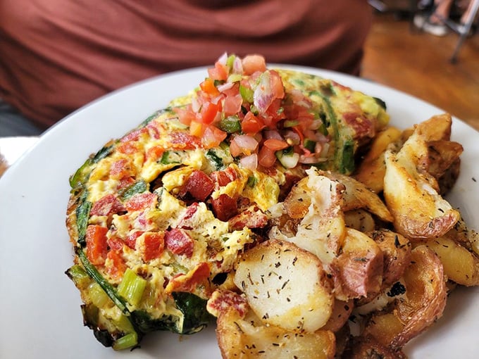 This omelet doesn't just contain vegetables; it celebrates them. The perfectly seasoned potatoes on the side are the unsung heroes of this plate.