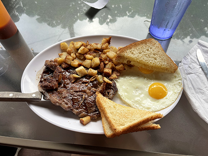 A breakfast trinity of perfectly seared steak, golden home fries, and sunny-side-up eggs—the morning equivalent of hitting the Pennsylvania lottery.