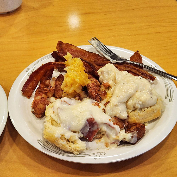 Breakfast nirvana achieved: crispy bacon, fluffy biscuits swimming in creamy gravy, and scrambled eggs that never saw the inside of a carton.