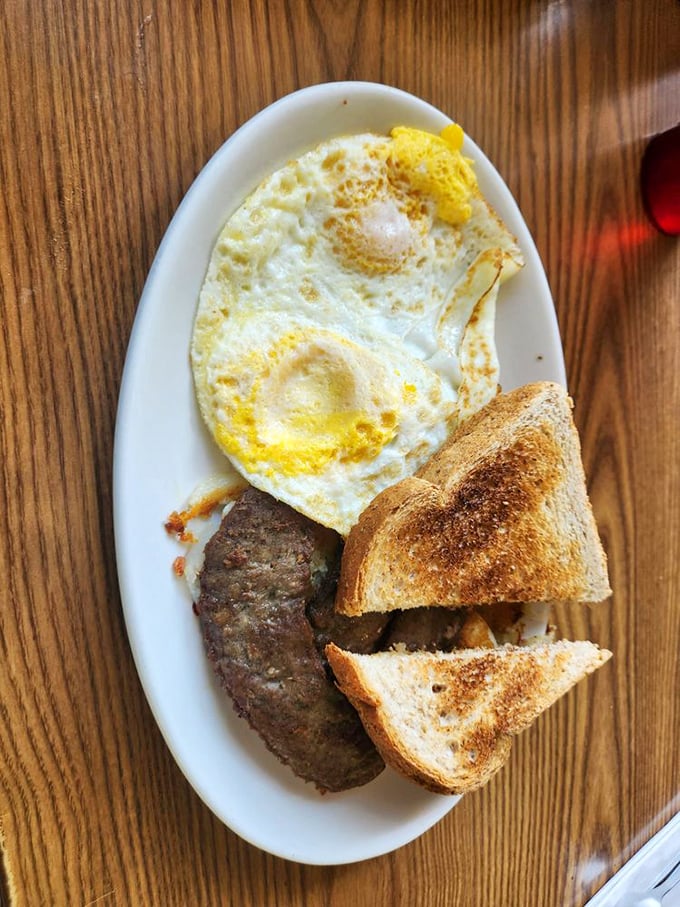 Breakfast perfection doesn't need fancy plating—just a sunny-side egg, perfectly browned sausage, and toast that's actually toasted right.