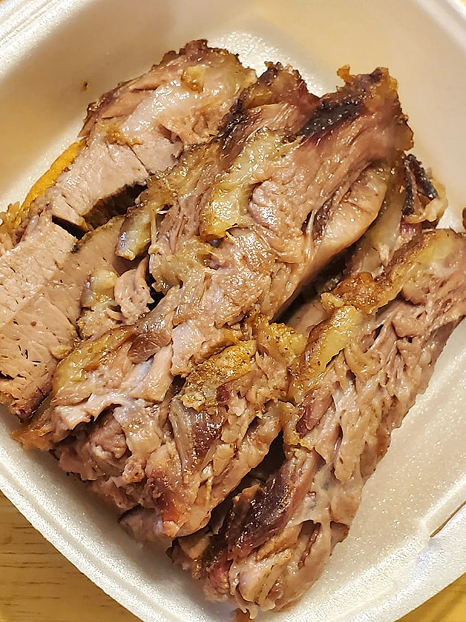 Behold the brisket in all its glory—tender, pink-ringed perfection that makes vegetarians question their life choices.
