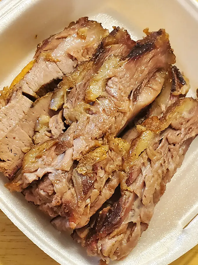 Behold the brisket in all its glory—tender, pink-ringed perfection that makes vegetarians question their life choices.