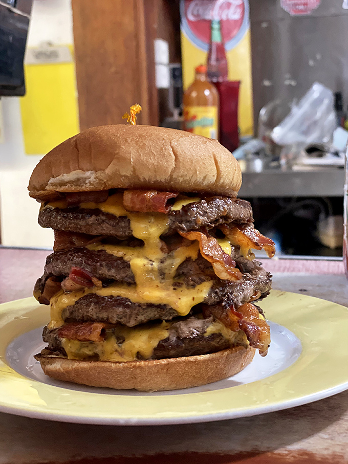 Behold the tower of power! This multi-patty masterpiece isn't just a burger—it's an engineering marvel with cheese as its structural support.