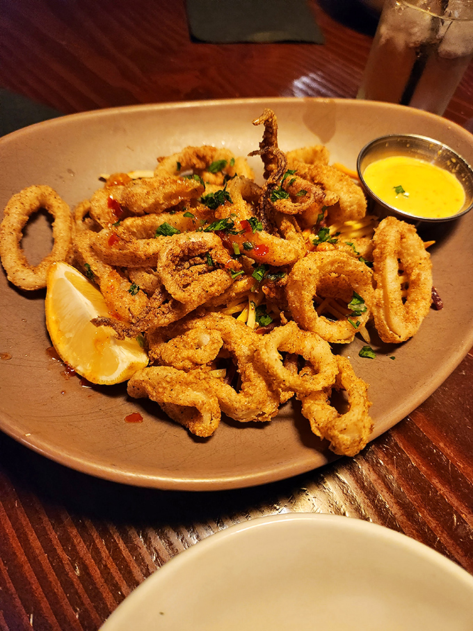 Golden calamari rings arrive like edible jewelry, each bite a crispy testament to perfect frying technique.