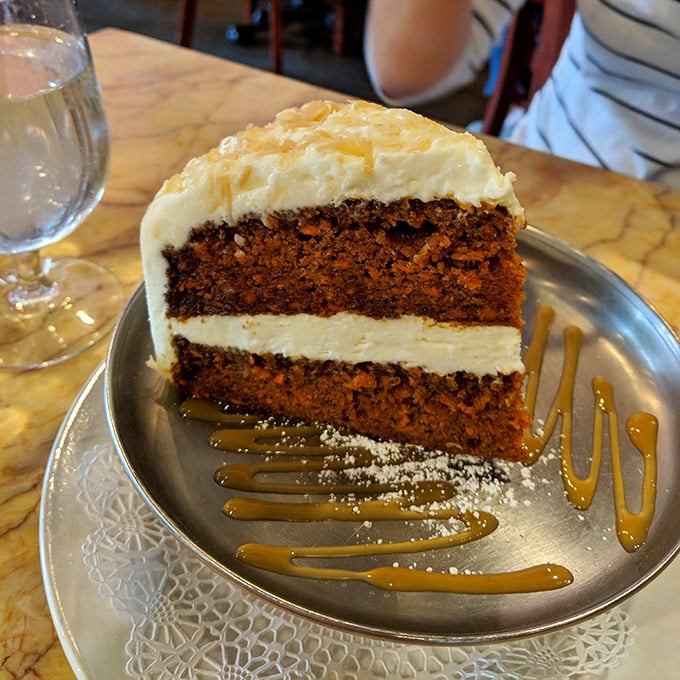 This towering carrot cake slice could end diplomatic disputes – layers of moist perfection crowned with cream cheese clouds.