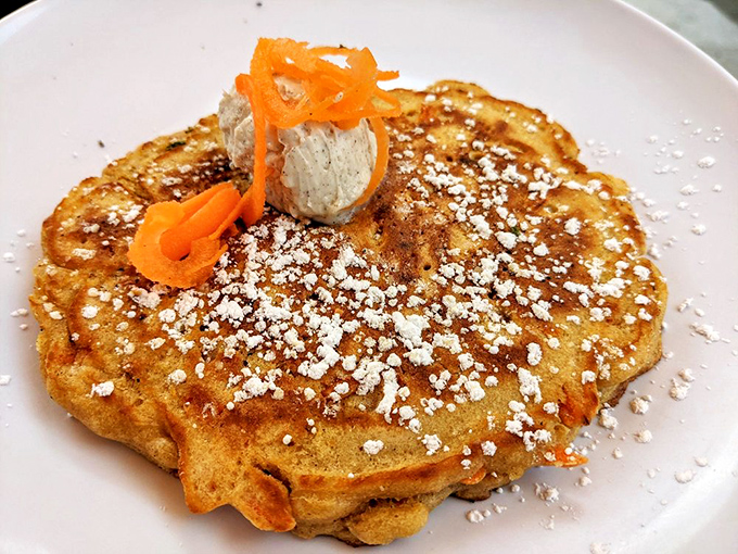 This isn't just a pancake – it's a golden canvas topped with powdered sugar snow and carrot ribbons that would make Bugs Bunny abandon his garden.