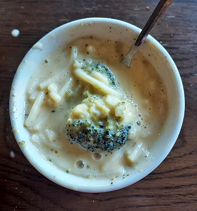 The legendary cheese soup that launches a thousand road trips—creamy, rich, and dotted with broccoli. One spoonful and you'll understand the obsession.