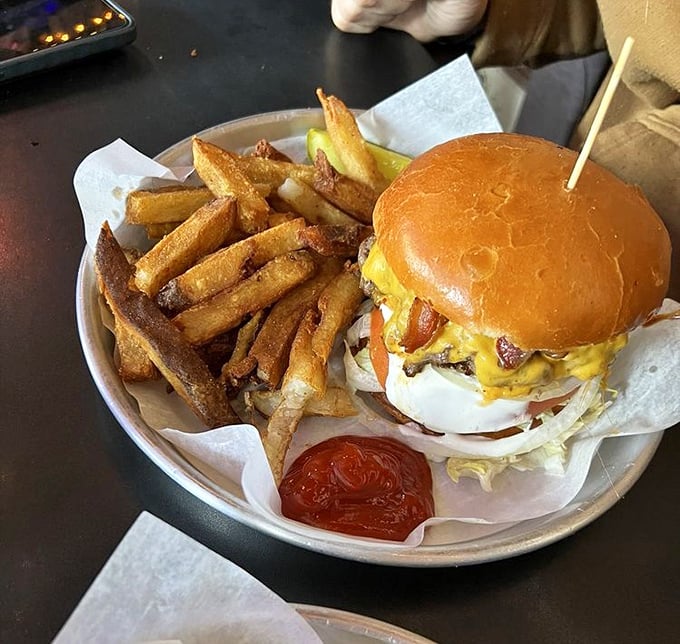 This isn't just a burger – it's an engineering marvel with a toothpick spire. The fries aren't sides; they're foundations for the impending food coma.