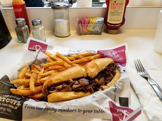 Behold the main attraction – thinly sliced ribeye nestled in a perfect roll with golden fries standing guard. The lean-forward-while-you-eat masterpiece.