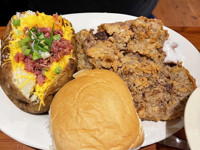 That's not just chicken fried steak—it's a masterpiece of crispy, peppery perfection alongside a loaded baked potato that's practically begging to be devoured.
