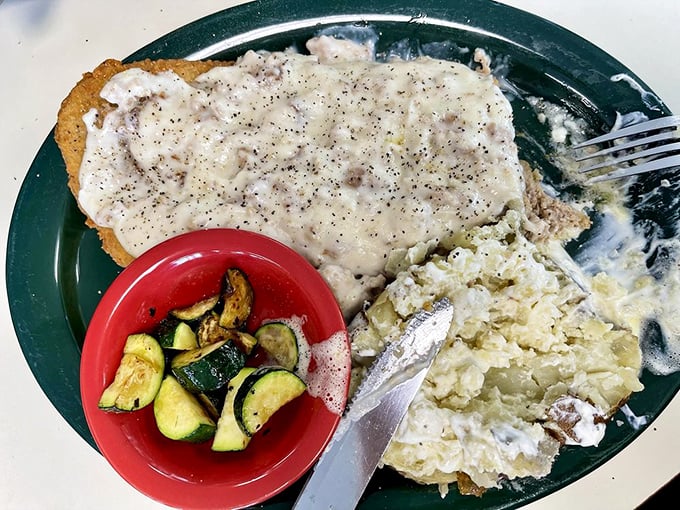 Behold the star of our show: chicken fried steak swimming in peppery gravy with a side of perfectly sautéed zucchini. Poetry on a plate.