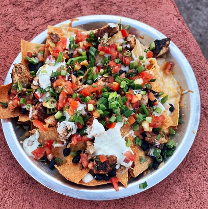 These nachos aren't just a dish—they're an architectural achievement of crispy chips, fresh toppings, and enough cheese to make Wisconsin nervous.