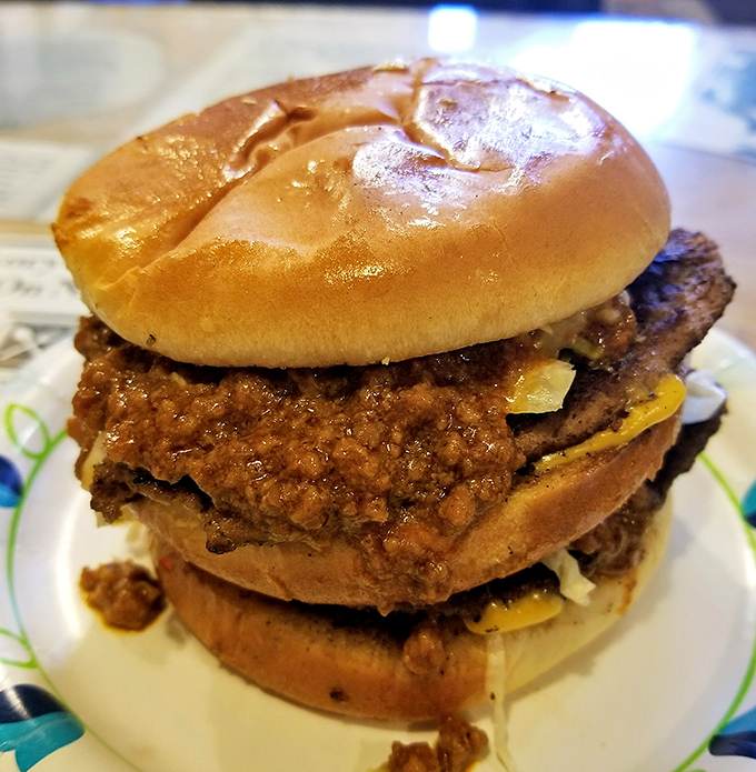 Not just any cheeseburger—this towering chili-drenched masterpiece requires strategic eating, multiple napkins, and absolutely zero first-date situations.