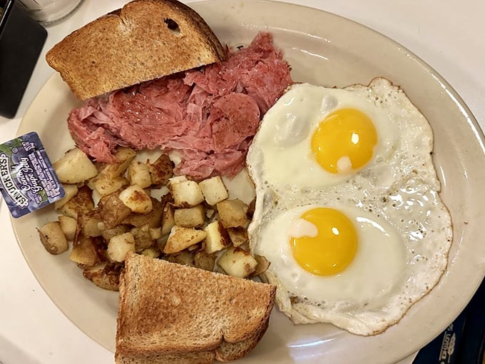 Breakfast perfection on a plate – those sunny-side-up eggs seem to be smiling at the mountain of thinly-shaved chipped ham and golden home fries.
