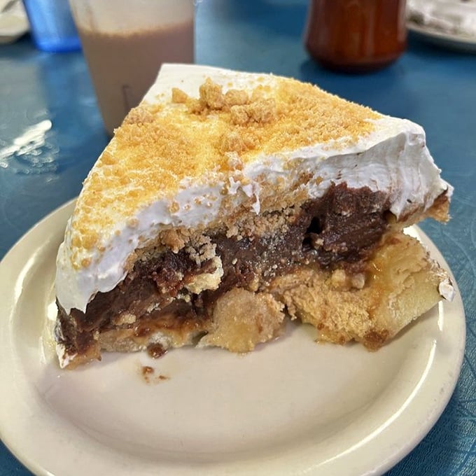 The legendary chocolate peanut butter pie in all its glory – layers of creamy peanut butter filling topped with whipped cream and crumbles. Diet plans have been abandoned for less.