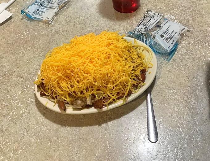 Cincinnati's famous 5-way chili in its natural habitat—a mountain of finely shredded cheddar that's practically begging you to dive in face-first.