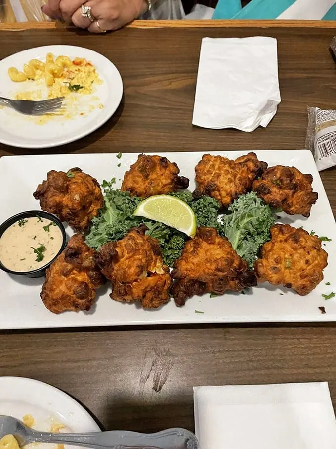 These conch fritters aren't just fried dough balls—they're golden-brown Caribbean postcards, crispy on the outside, tender within, begging to be dipped in that sauce.