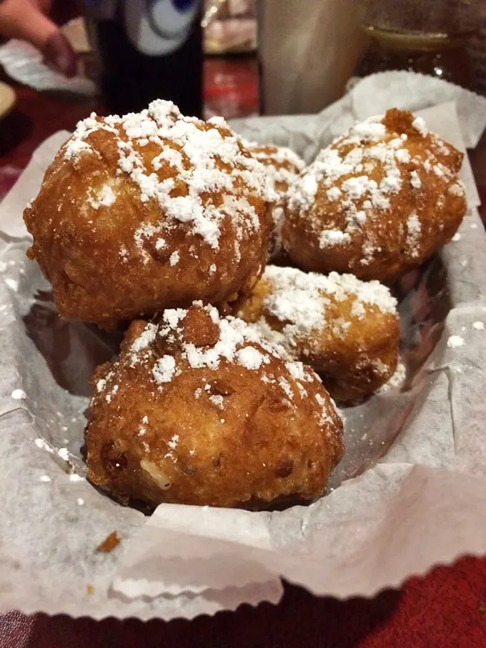 Golden-brown corn fritters dusted with powdered sugar—proof that sometimes the best things in life are deep-fried and slightly sweet.