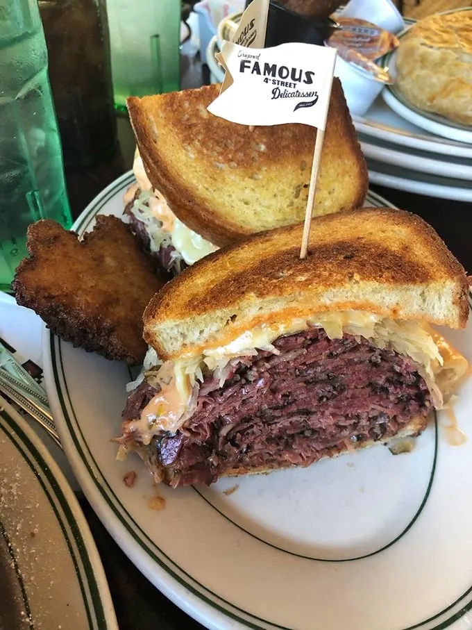 Meet the Reuben that launched a thousand food pilgrimages. Corned beef stacked so high it should have its own altitude warning—pure sandwich architecture.