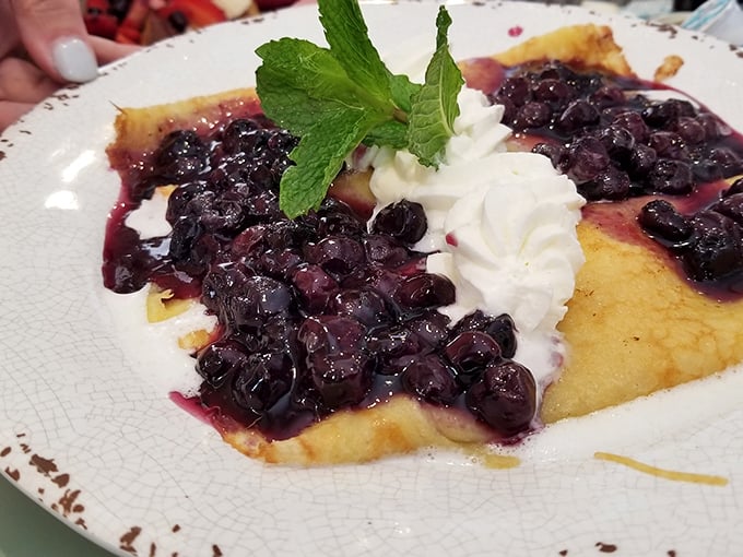 Blueberry crepes that make you question why you ever settled for cereal. That mint garnish isn't just for show—it's the exclamation point on a breakfast statement.