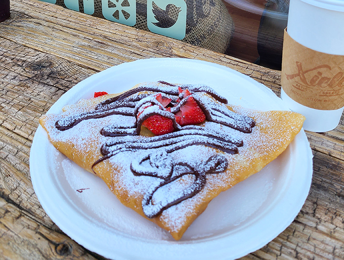 This isn't just a crepe—it's edible architecture. Chocolate drizzle, fresh strawberries, and powdered sugar create the holy trinity of breakfast indulgence.