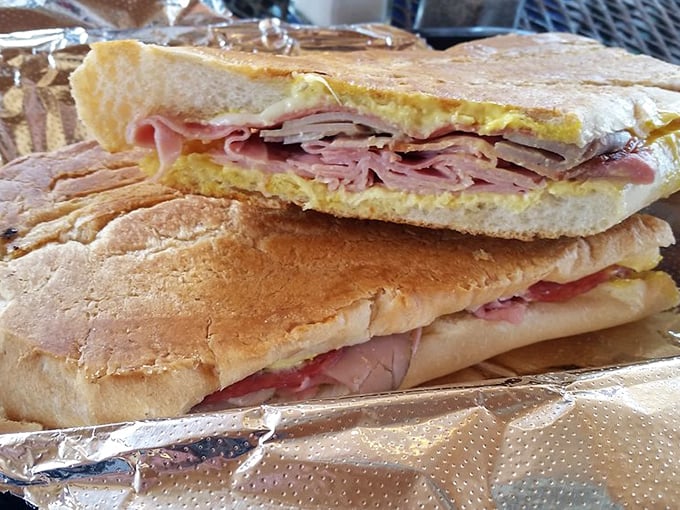 Behold sandwich architecture at its finest—layers of ham and pork creating the perfect meat-to-bread ratio that would make Frank Lloyd Wright weep with joy.