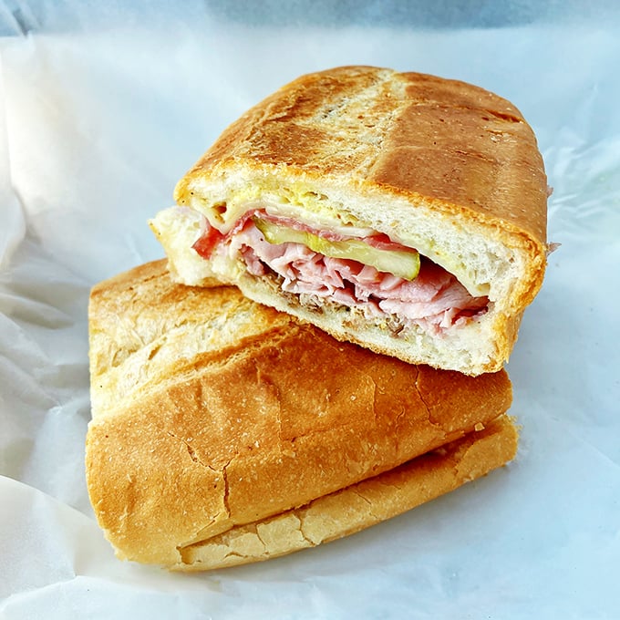 Behold the Cuban sandwich in its natural habitat! Layers of meat and cheese pressed between bread so perfect it should have its own Instagram account.