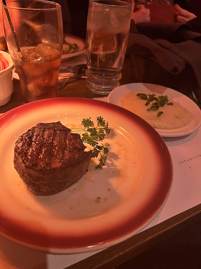 Behold the star of the show—a perfectly seared filet mignon standing proudly on its plate like a meaty monument to culinary excellence.