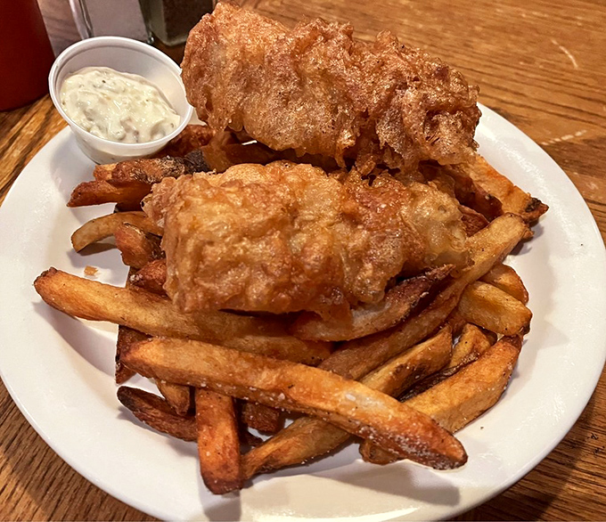 Golden-battered fish perched atop a mountain of proper chips – this isn't fast food, it's a slow-down-and-savor masterpiece.