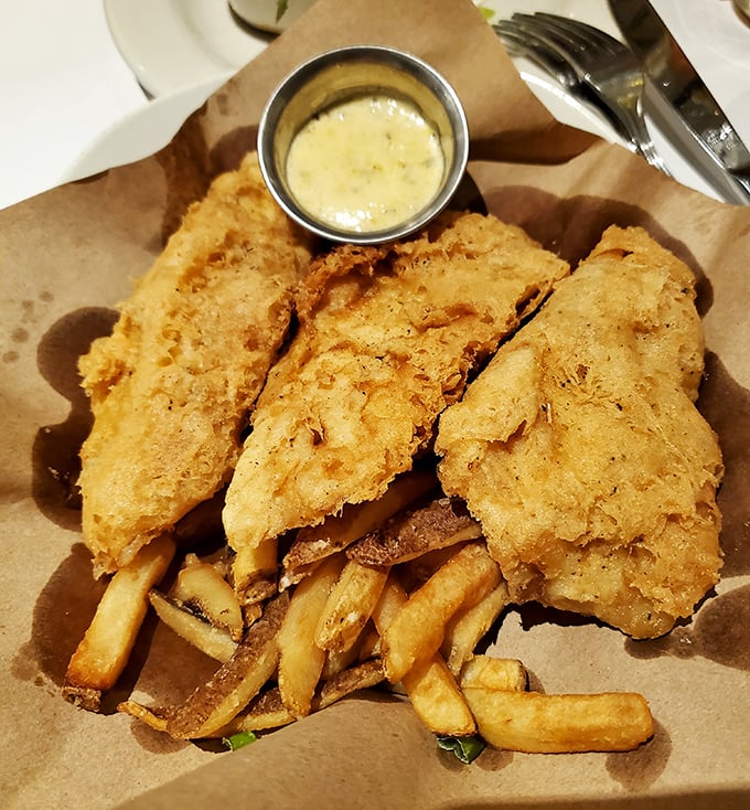 Golden-battered fish resting on a bed of crispy fries – this isn't just fish and chips, it's what fish dreams of becoming when it grows up.