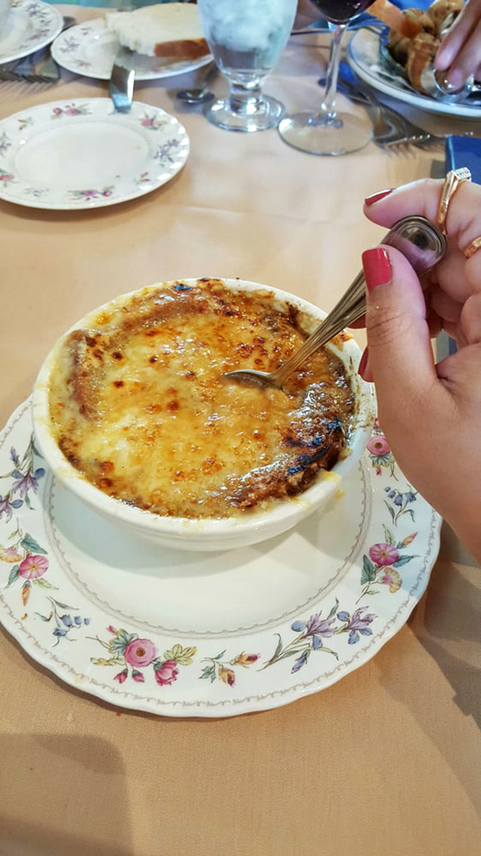 The legendary French onion soup arrives like a cheese volcano waiting to erupt. That first spoonful breaking through the crust is pure theater.