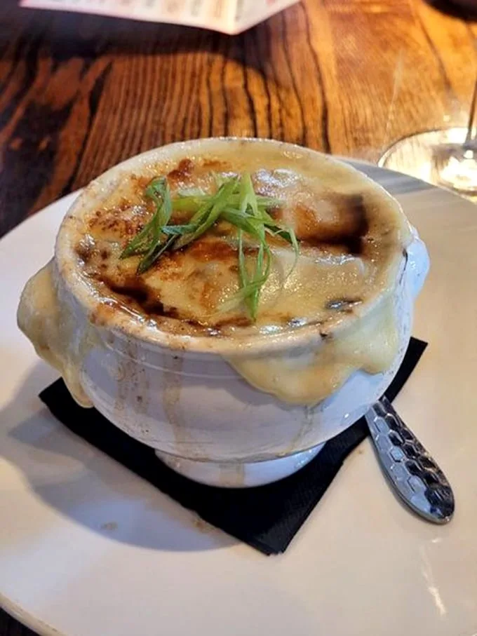 The legendary French onion soup in all its glory – that cheese pull could win Olympic medals. A bubbling cauldron of comfort that's worth every savory, soul-warming spoonful.