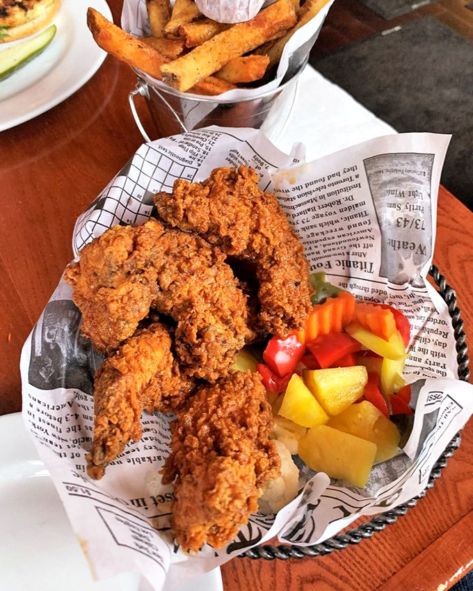 Golden-brown fried chicken that shatters at first bite, revealing juicy meat beneath—served with colorful pickled vegetables that cut through the richness perfectly.