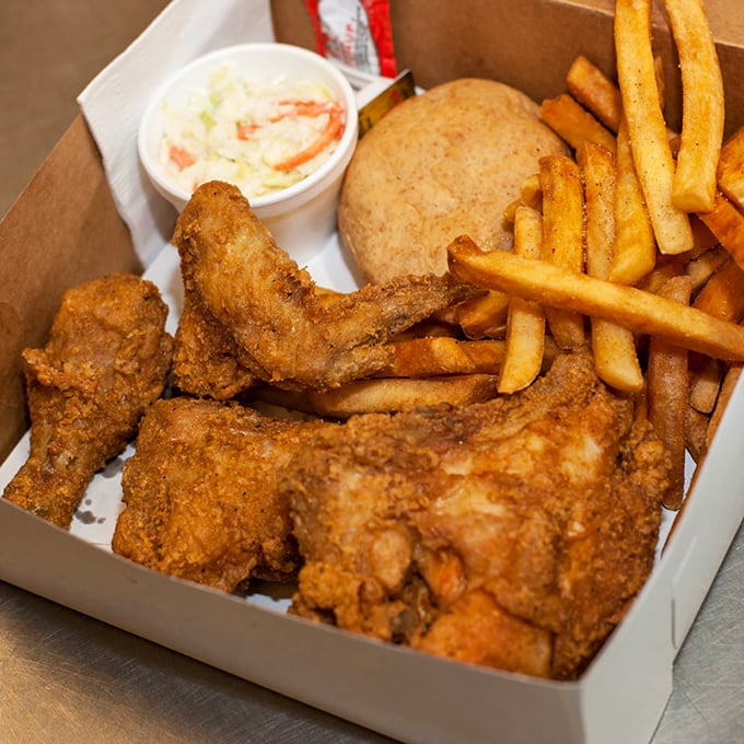 Golden-brown fried chicken nestled against crispy fries and creamy slaw – a holy trinity of comfort that makes time stand still.