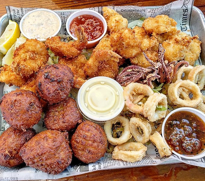 A seafood festival on newspaper—where conch fritters, fried shrimp, and calamari gather like old friends celebrating the bounty of the sea.