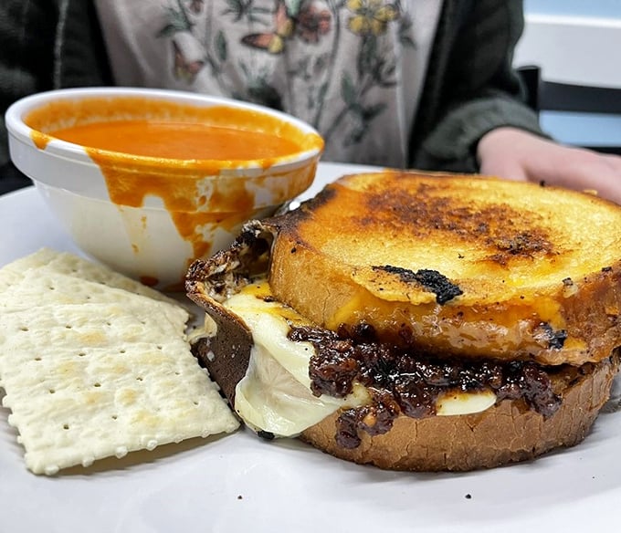This isn't just melted cheese on bread—it's a childhood memory transformed into adult indulgence, complete with soul-warming tomato soup for dunking.