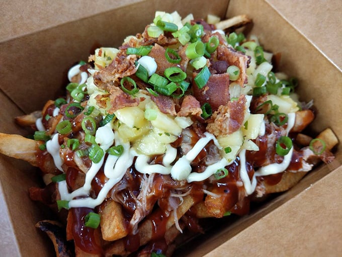 These loaded fries aren't just a snack, they're an architectural masterpiece. Layers of bacon, scallions, and sauce creating a potato skyscraper worth demolishing.