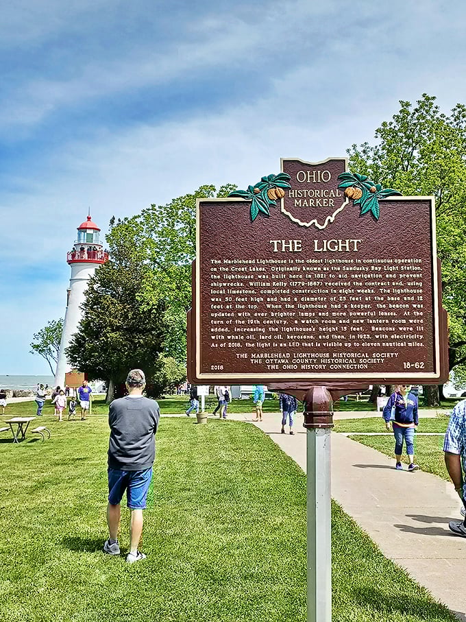 History buffs gather around the Ohio Historical Marker, soaking up facts about the oldest continuously operating lighthouse on the Great Lakes.