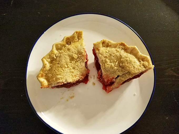 Two slices of ruby-red pie with crumb topping sit like edible jewels. This isn't just dessert—it's the reason elastic waistbands were invented.