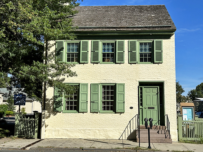 Crisp green shutters against cream-colored brick—this historic home doesn't just preserve history, it wears it with understated elegance.
