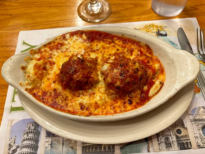 These meatballs aren't just sitting on cheese—they're lounging on a bubbling hot tub of marinara and mozzarella like they own the place.