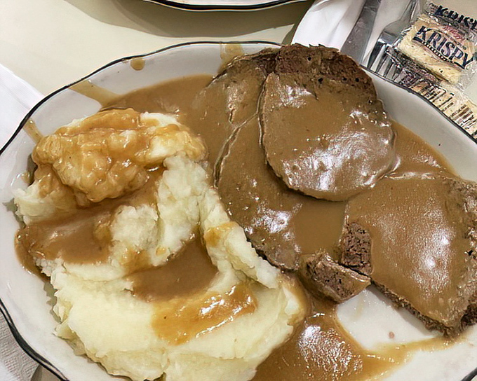 Behold the star attraction: meatloaf swimming in gravy alongside mashed potatoes. Comfort food that whispers, "Everything's going to be okay."
