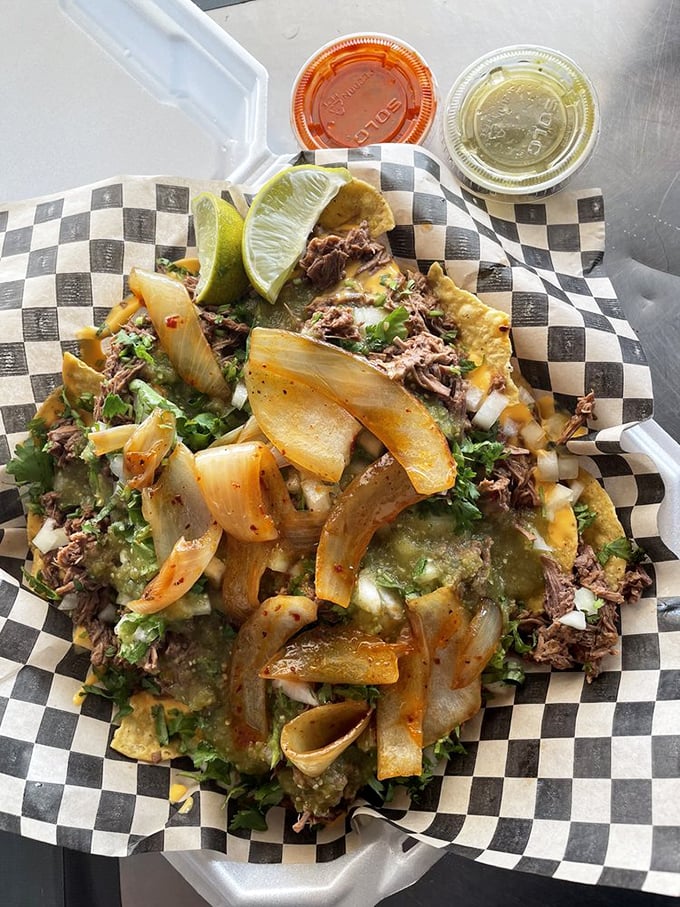 Nachos aren't just a snack here—they're an architectural masterpiece. That lime wedge isn't decoration; it's the perfect acid to cut through all that glorious richness.