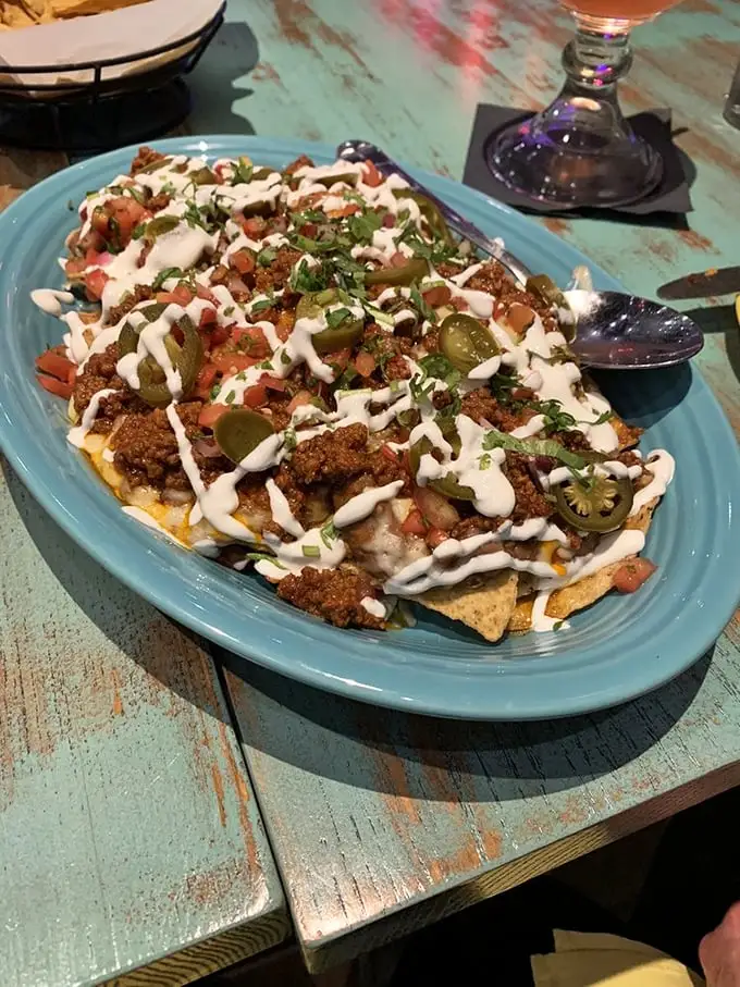 These nachos aren't just a dish—they're an architectural masterpiece of cheese, jalapeños, and perfectly distributed toppings. No sad, naked chips here!