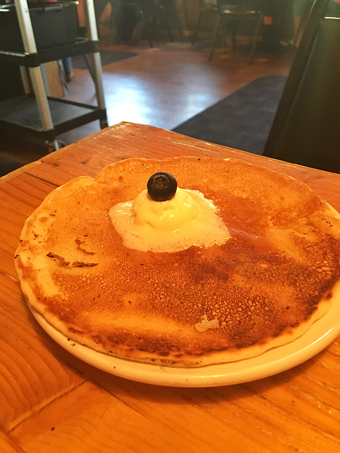 This isn't just a pancake—it's a golden-brown canvas of breakfast perfection, topped with a dollop of butter and chocolate chips.