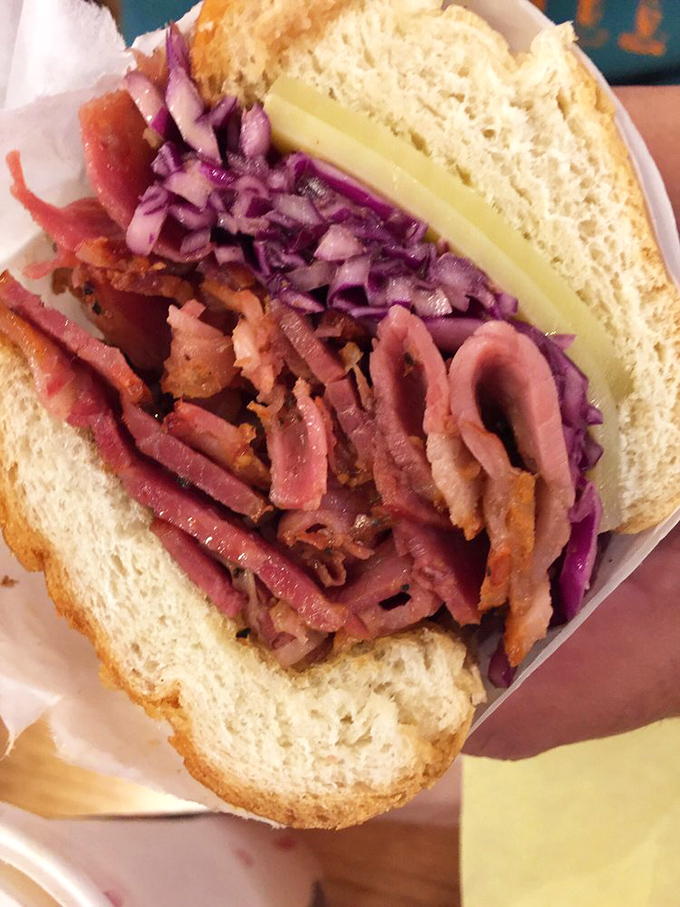 Behold the star of the show: pink, peppery pastrami piled high with purple cabbage and Swiss cheese. Poetry between bread.