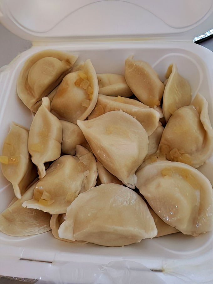 Plump, tender pierogies nestled together like edible pillows of joy. Resistance is futile, just surrender to the carb-laden bliss.
